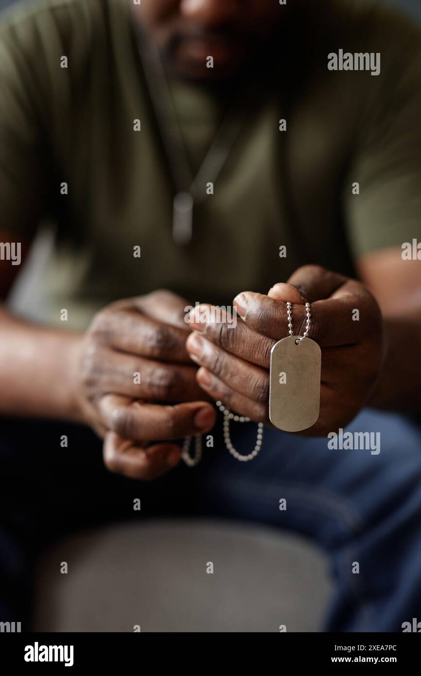 Vertical close up of unrecognizable Black man as army veteran holding ...