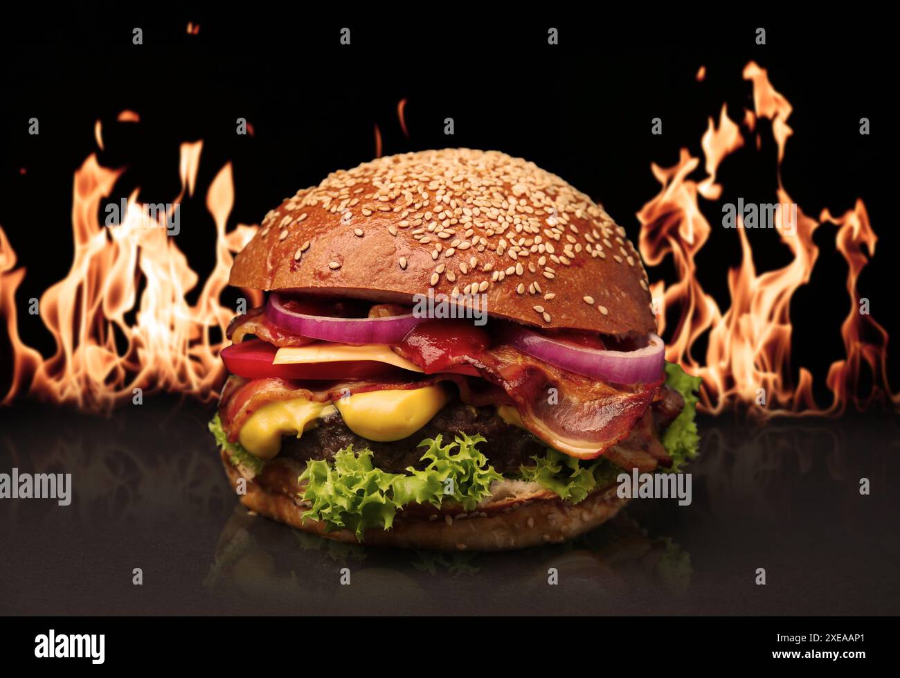 Yummy burger on dark table against flame Stock Photo - Alamy
