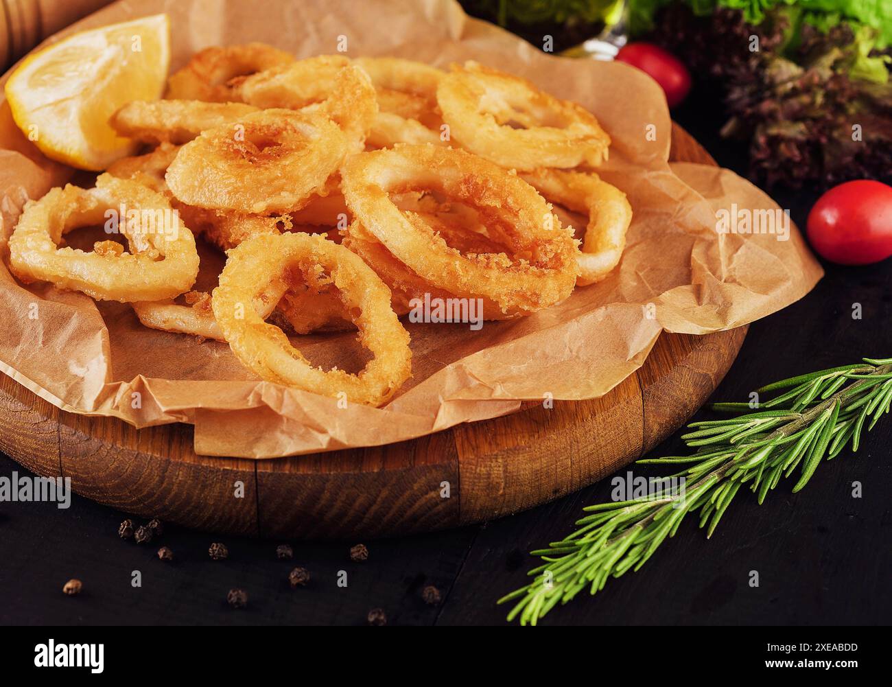 Oven baked breaded calamari rings served with lemon Stock Photo - Alamy