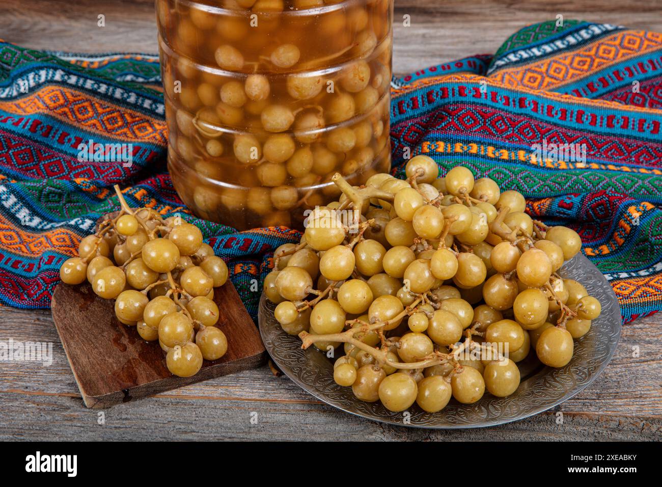 Pickled grapes in a plastic jar. Delicious pickled unripe grapes ...