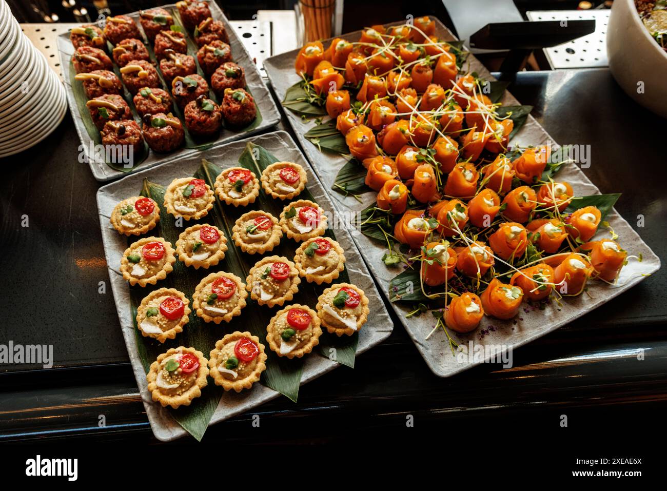 An array of gourmet appetizers, elegantly presented on trays. Event catering with tartlets and ...