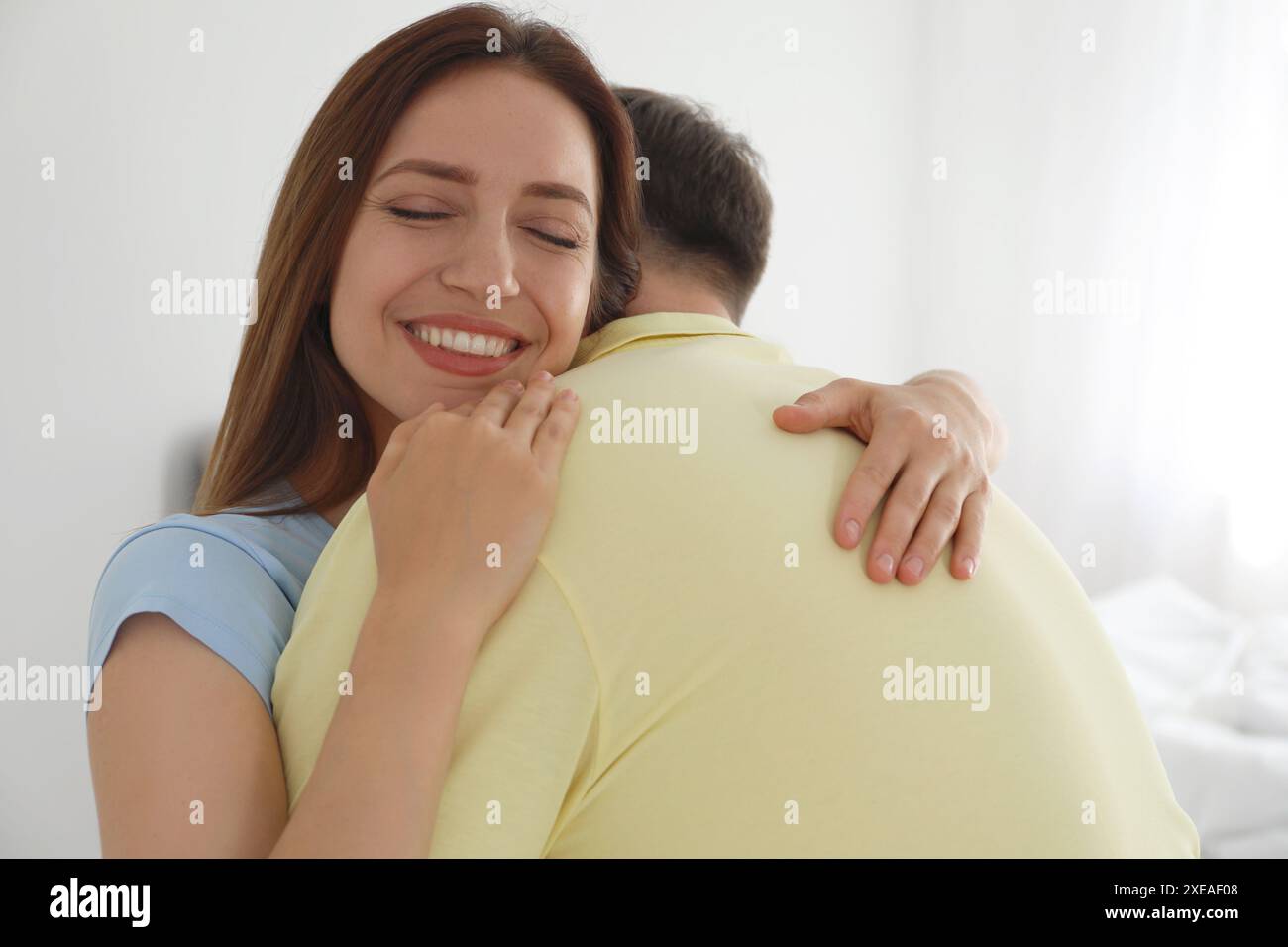 Happy woman hugging her boyfriend at home Stock Photo - Alamy
