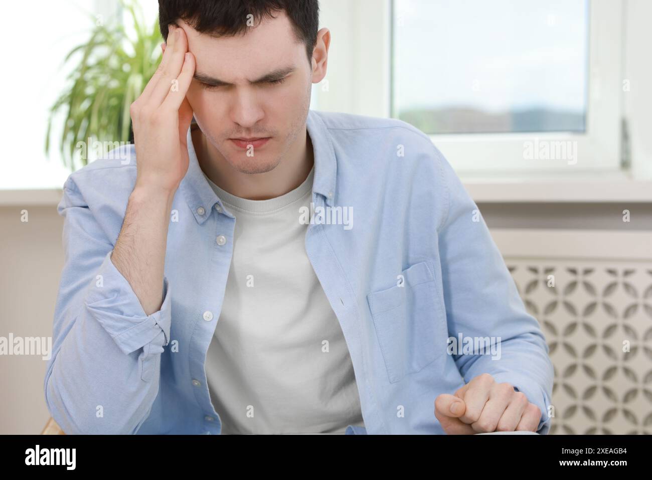 Sad man suffering from headache at home Stock Photo - Alamy
