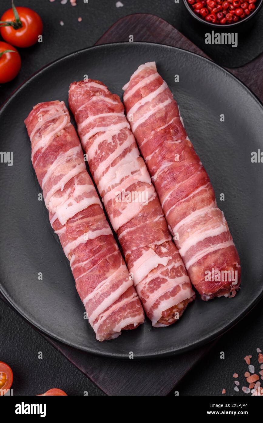 Raw minced meat wrapped in bacon with salt and spices or cevapcici ...