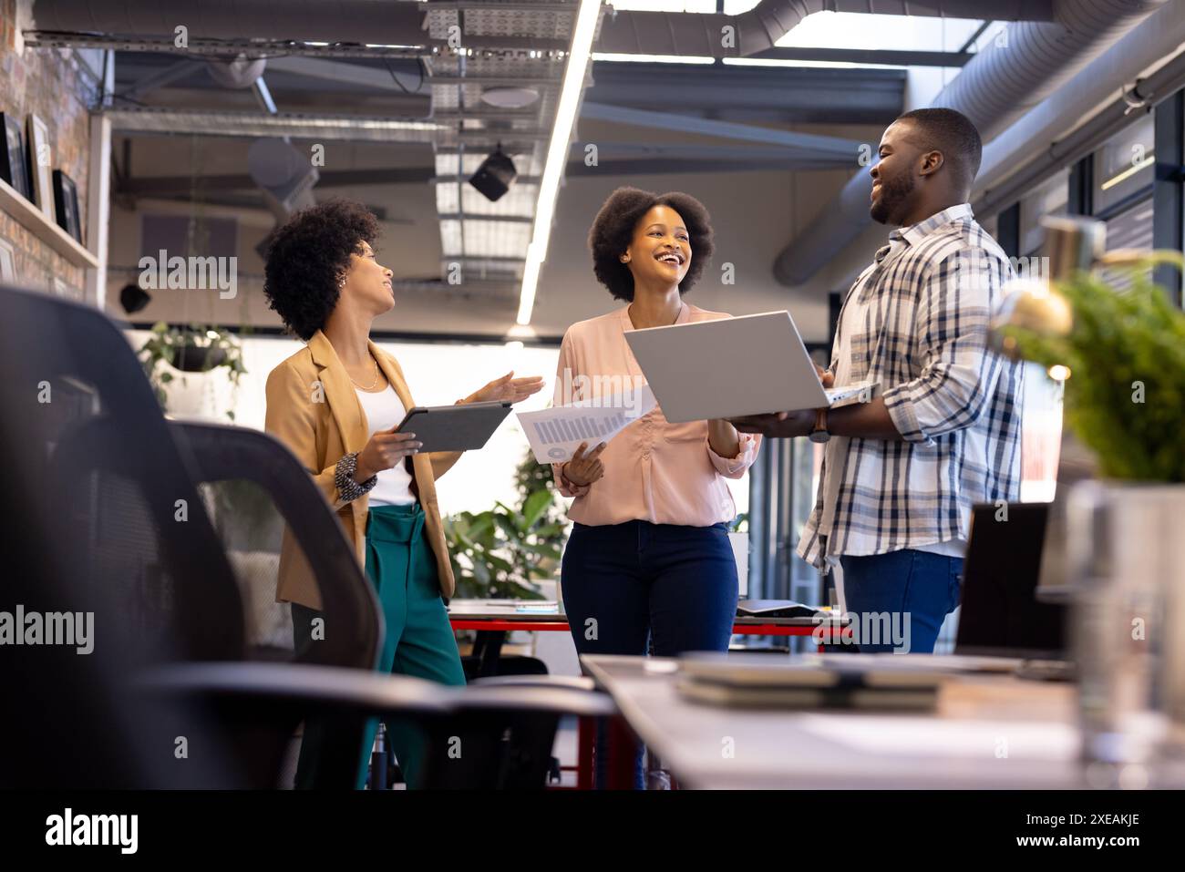 Business team discussing project, holding laptops and documents in modern office Stock Photo - Alamy