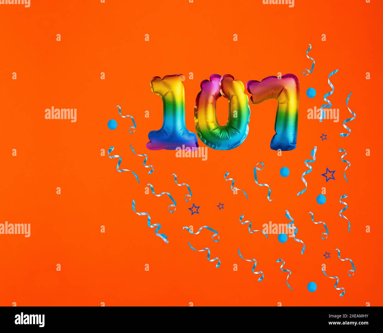 Confetti explosion with number 107 balloon - Celebration on orange ...