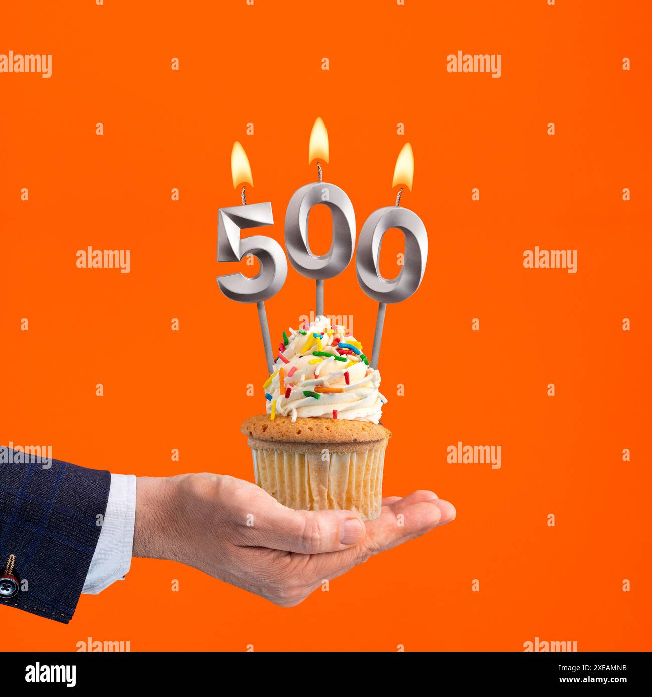 Hand holding birthday cupcake with number 500 candle - background ...
