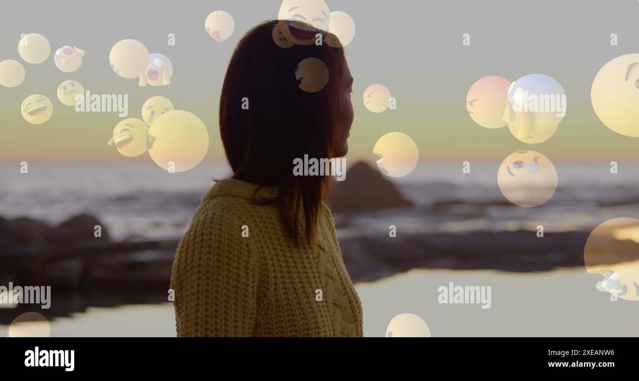 Image of falling emoji over woman on the beach Stock Photo - Alamy