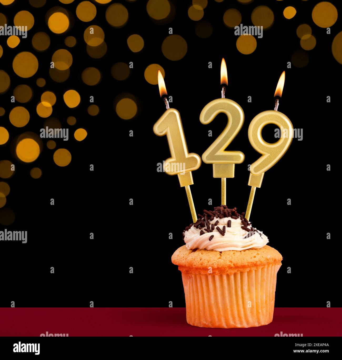 Number 129 birthday candle - Cupcake on black background with out of ...