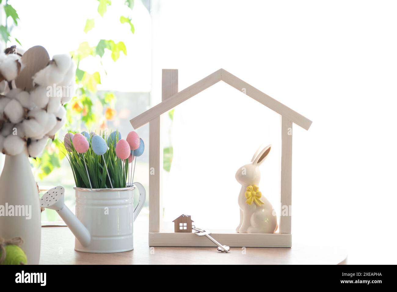 Key and tiny house of cozy home with Easter decor with rabbit and eggs ...