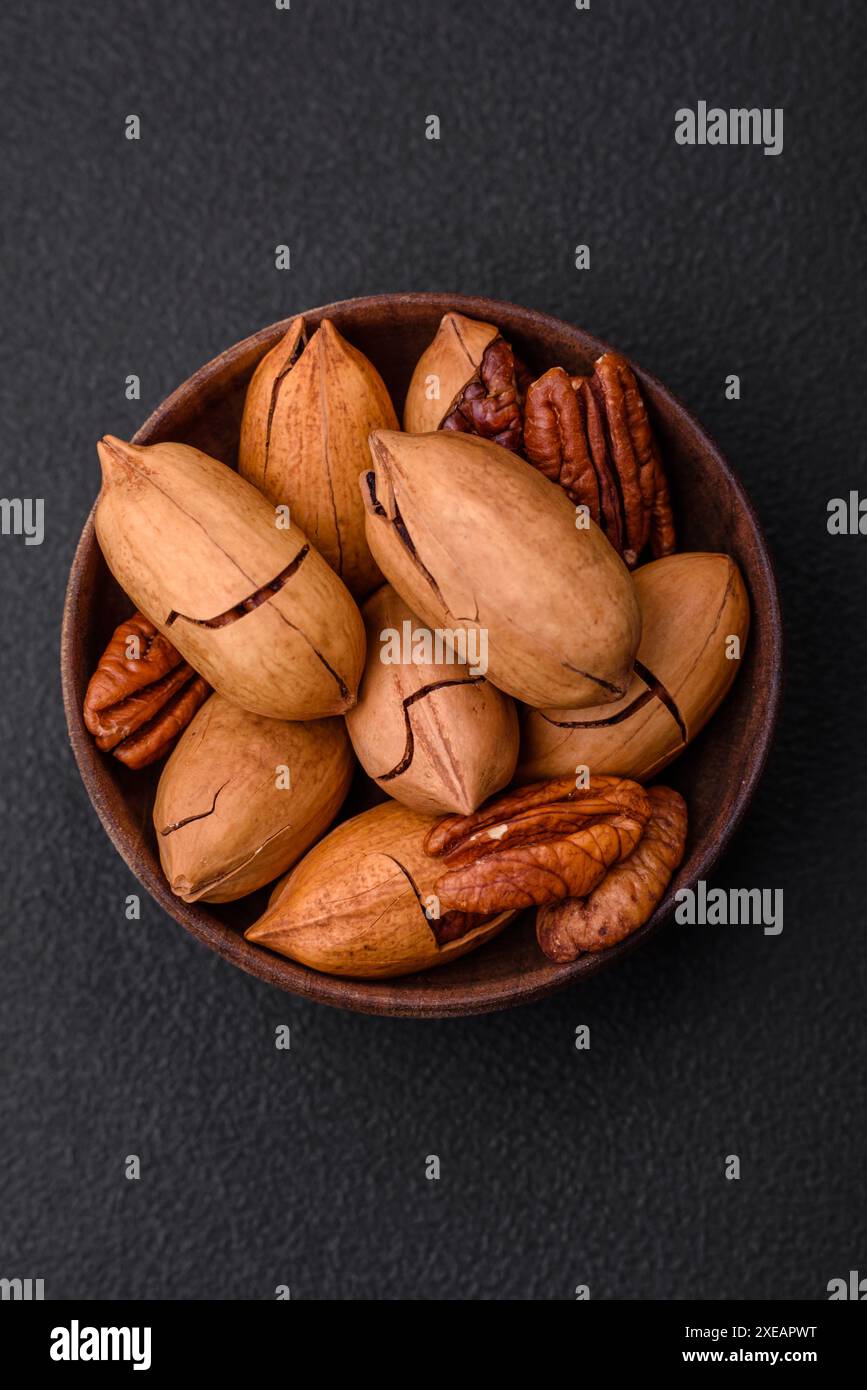 Pecan nuts in shell and peeled in a wooden round bowl Stock Photo - Alamy