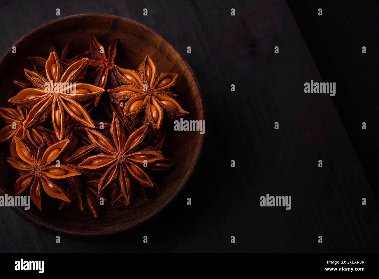 Star shaped spice star anise in a wooden round bowl Stock Photo - Alamy