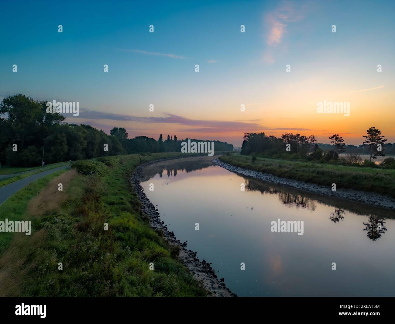 Dawn's First Light Reflecting on a Calm Canal with Pathway Stock Photo ...
