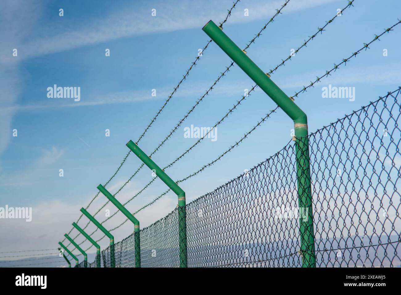 Green steel wire mesh fence around the airport area. Restricted area ...