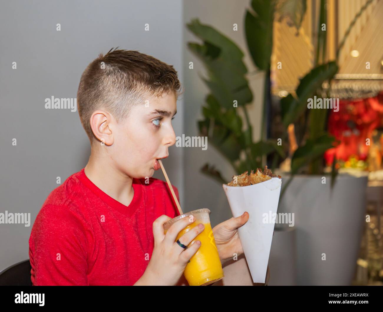 Child model eating a dessert on a rainy afternoon on a bench in the ...