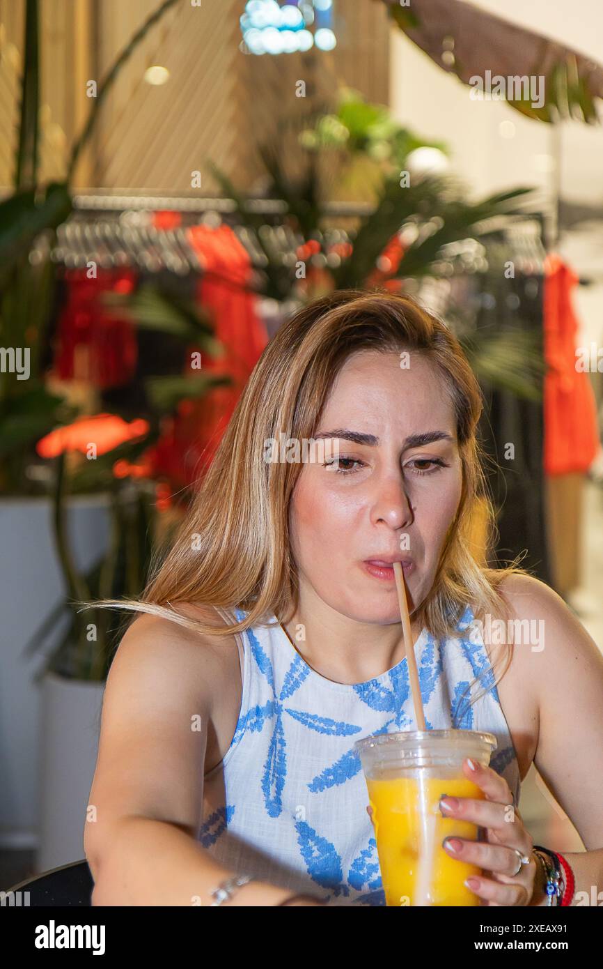 Young model drinking cold orange juice Stock Photo - Alamy