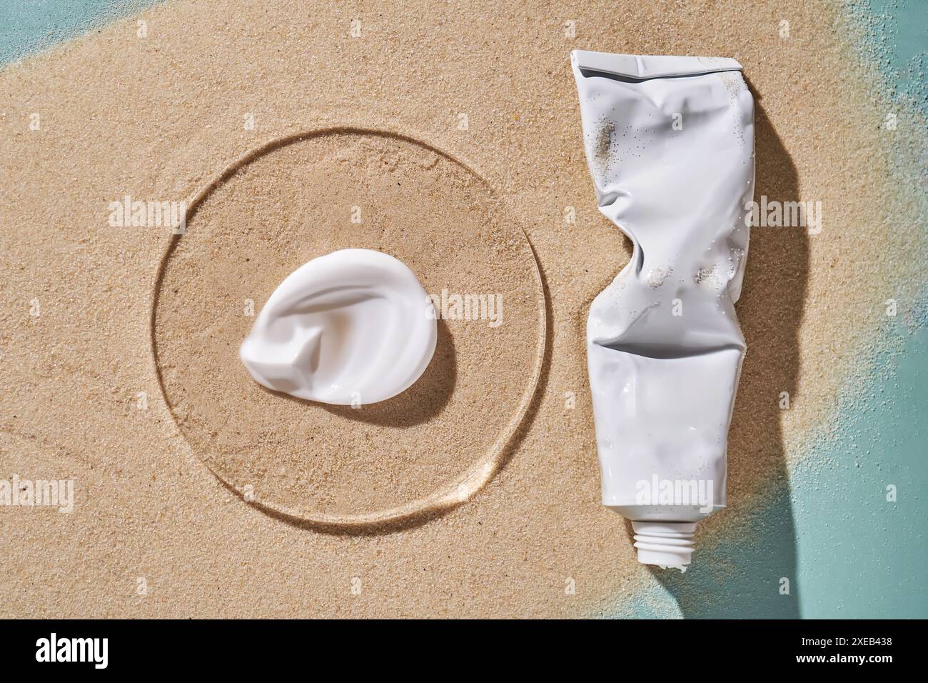 A tube of moisturizing sunscreen and a smear on a sandy background ...