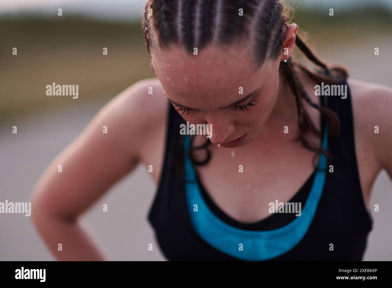 A close-up captures the raw dedication of a female athlete as she rests ...