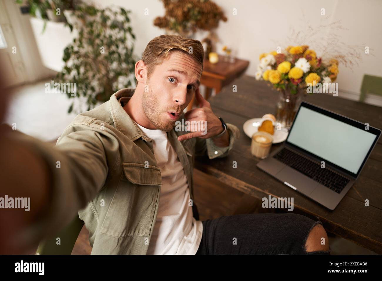 Handsome stylish young man takes selfie in cafe while working or ...