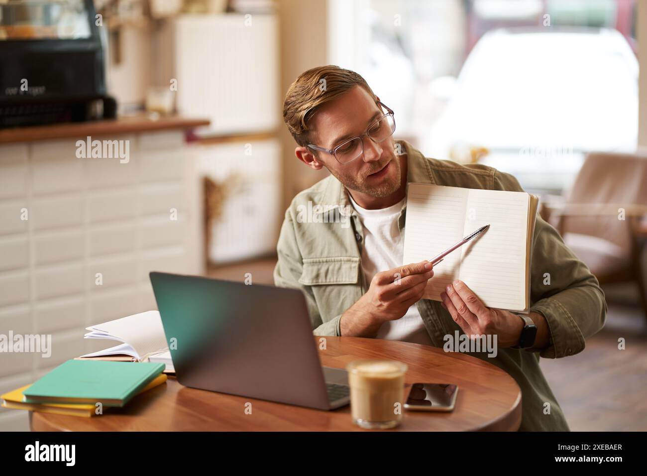 Portrait of handsome young man giving lessons online, showing exercises ...