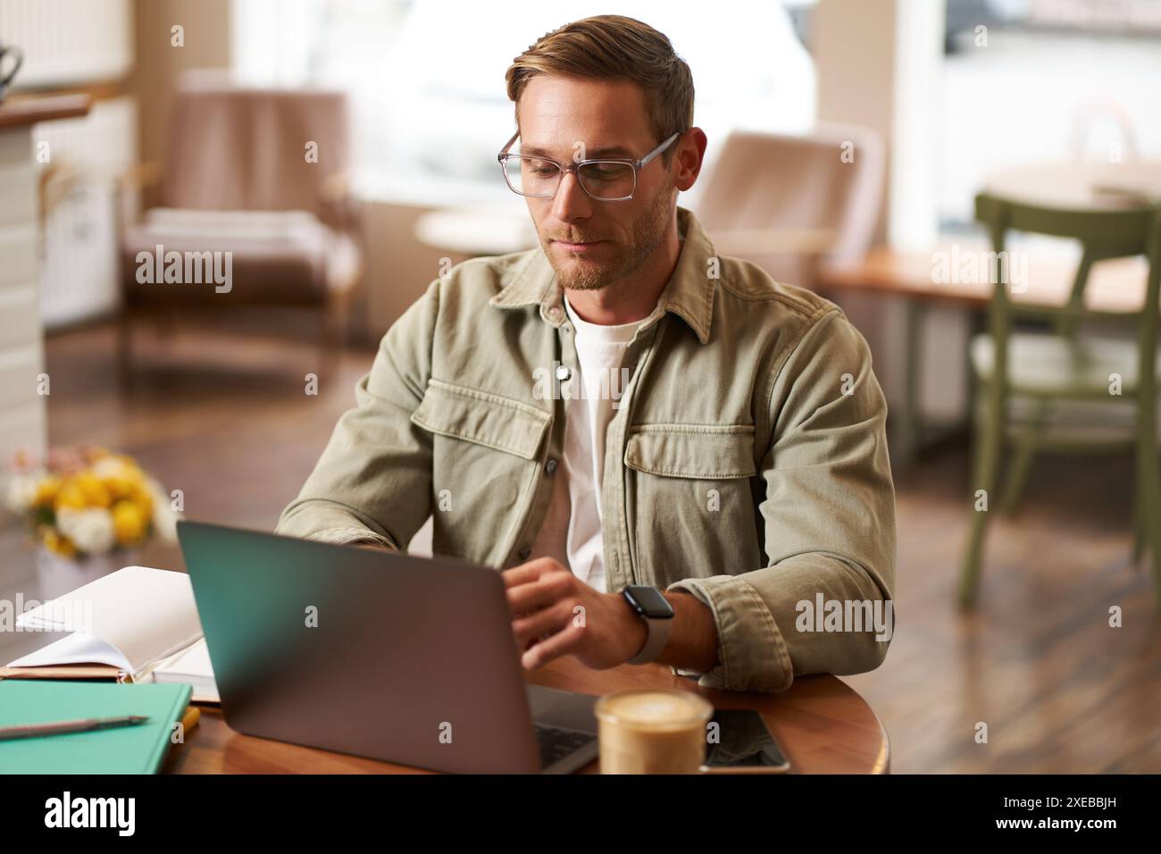 Remote work and freelance concept. Handsome man in glasses sits with ...