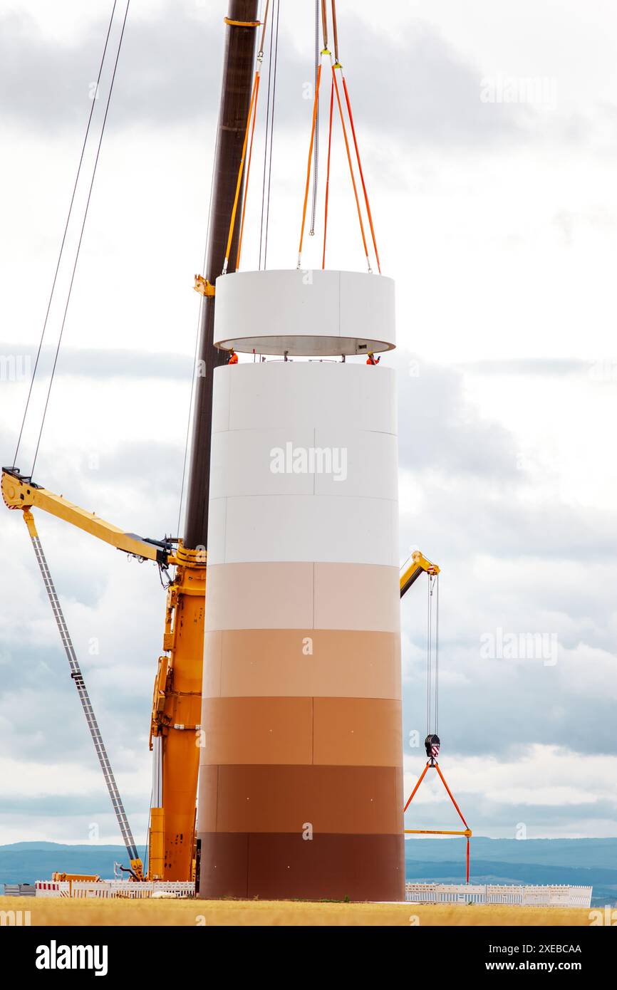 Building and assembling a construction windmill by crane. Farmland with ...