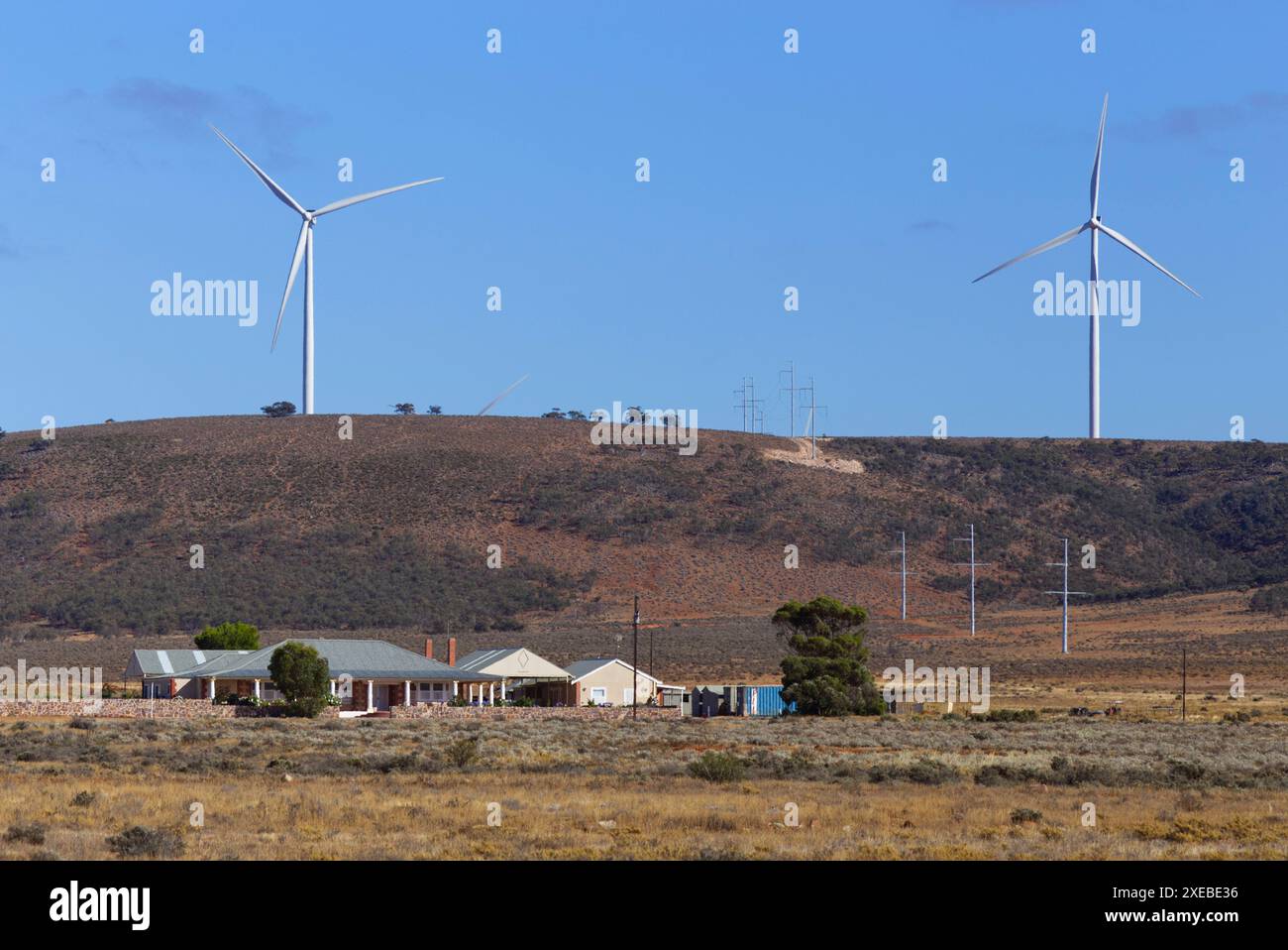 Farm House in front of giant Wind Turbines which line the hills at ...