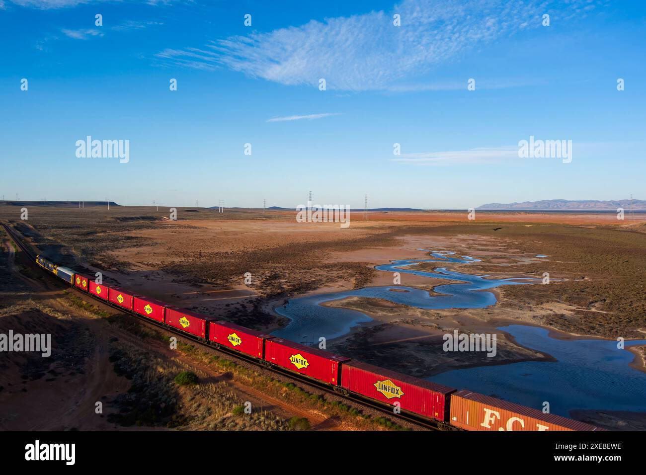 Aerial of container intermodal freight train crossing the vast open ...