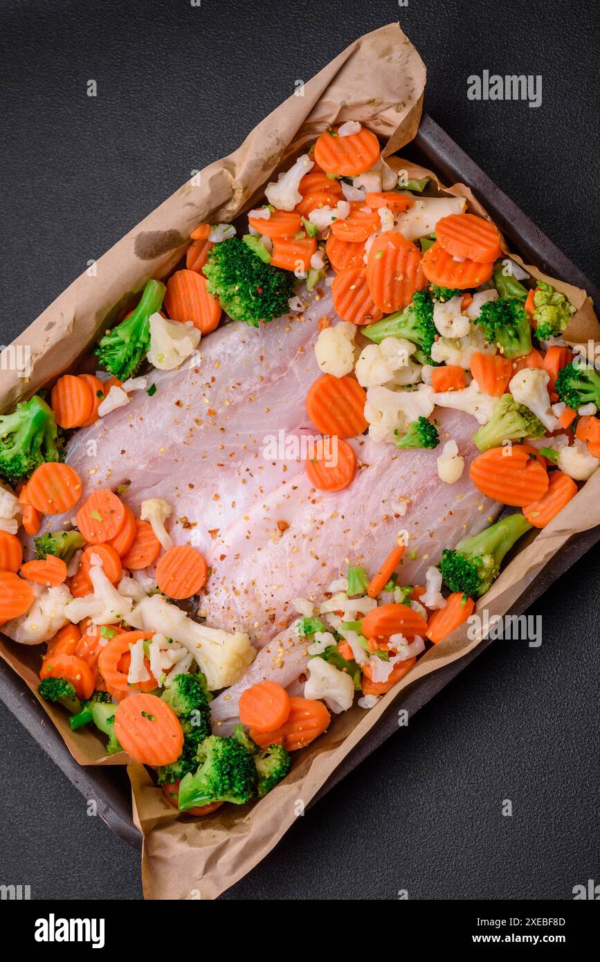 Raw sea bass fish fillet with salt, spices and vegetables in a baking ...