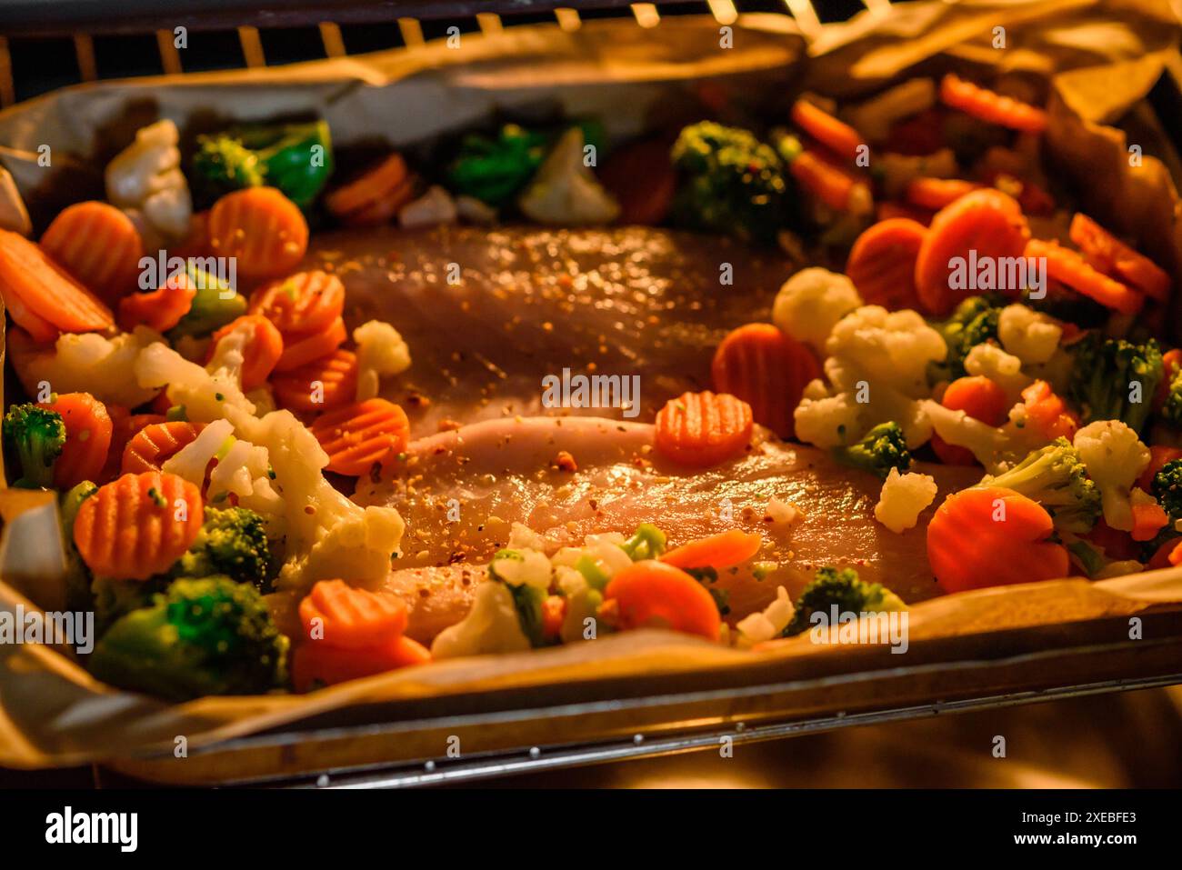 Raw sea bass fish fillet with salt, spices and vegetables in a baking ...