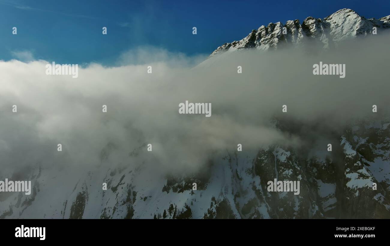 Flying through clouds between mountains Stock Photo - Alamy