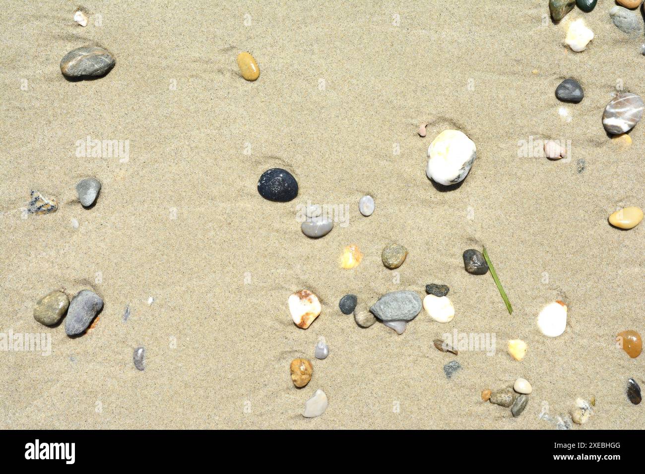 Different colored pebbles on the sand beach Stock Photo - Alamy