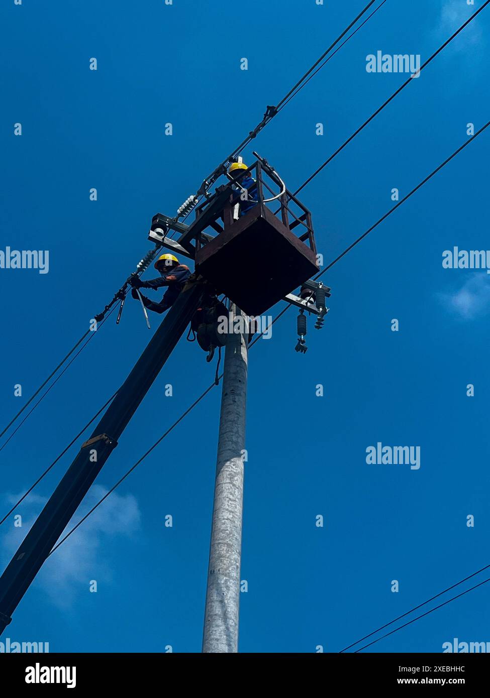 lineman or Electricians are climbing on electric poles to install and ...
