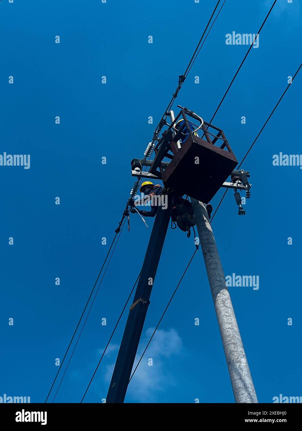 lineman or Electricians are climbing on electric poles to install and ...