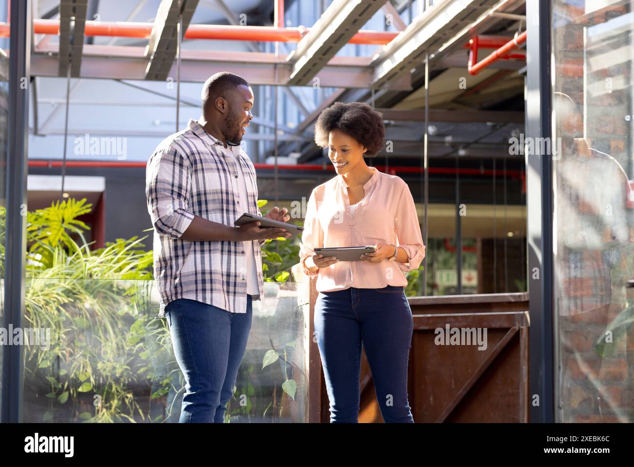 Business people discussing project using tablets in modern office ...