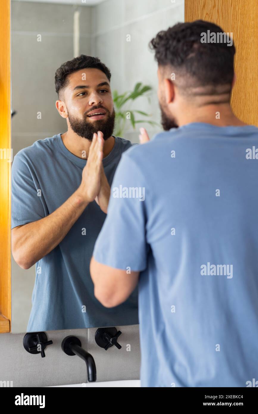 At home, Man in bathroom mirror grooming beard, focusing on personal ...