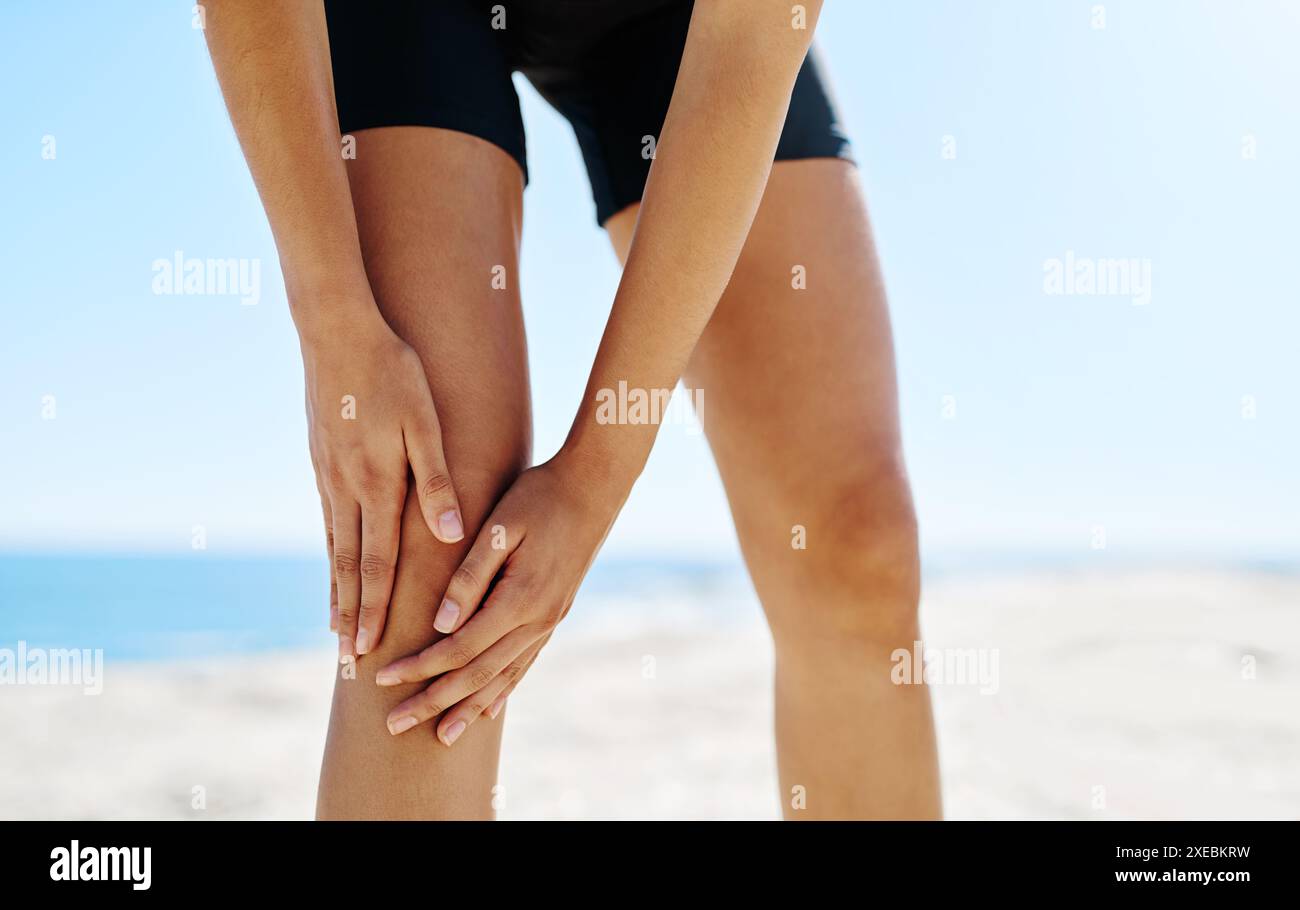 Sports, knee pain and person by beach with injury, muscle strain and ...