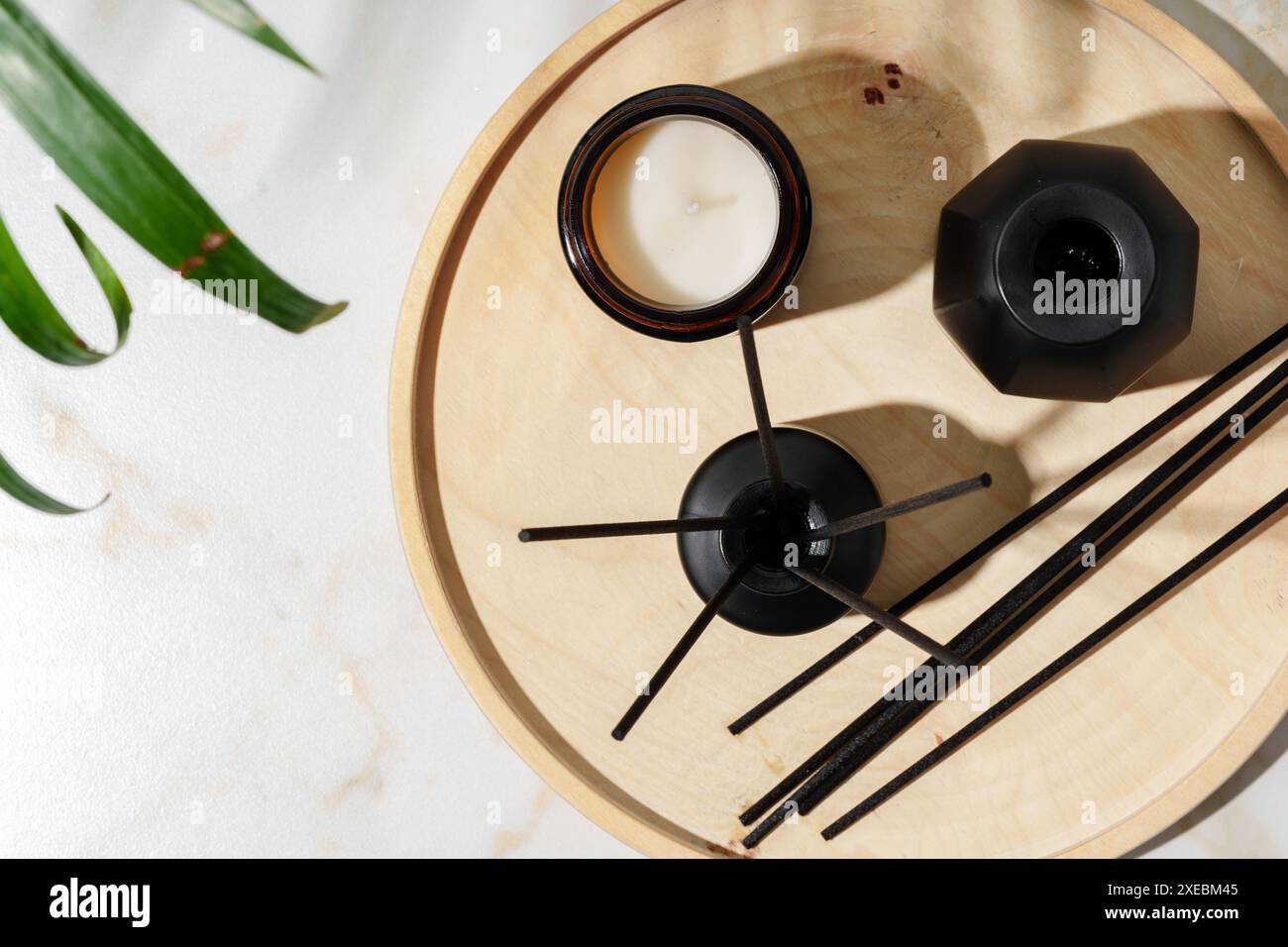 Black Reed Diffuser, Amber Candle, and Wooden Tray on White Surface ...