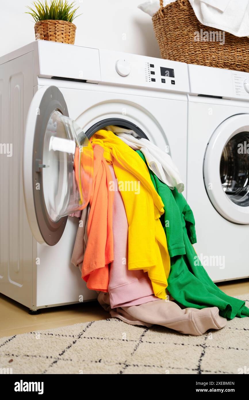 White Laundry Appliances With Colorful Clothes Overflowing From Washing ...