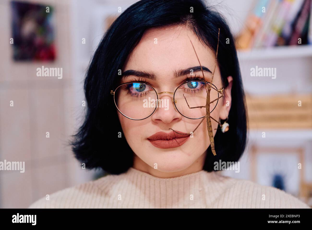 A serene moment as a young woman poses with her beloved stick insect, showcasing the unique bond ...
