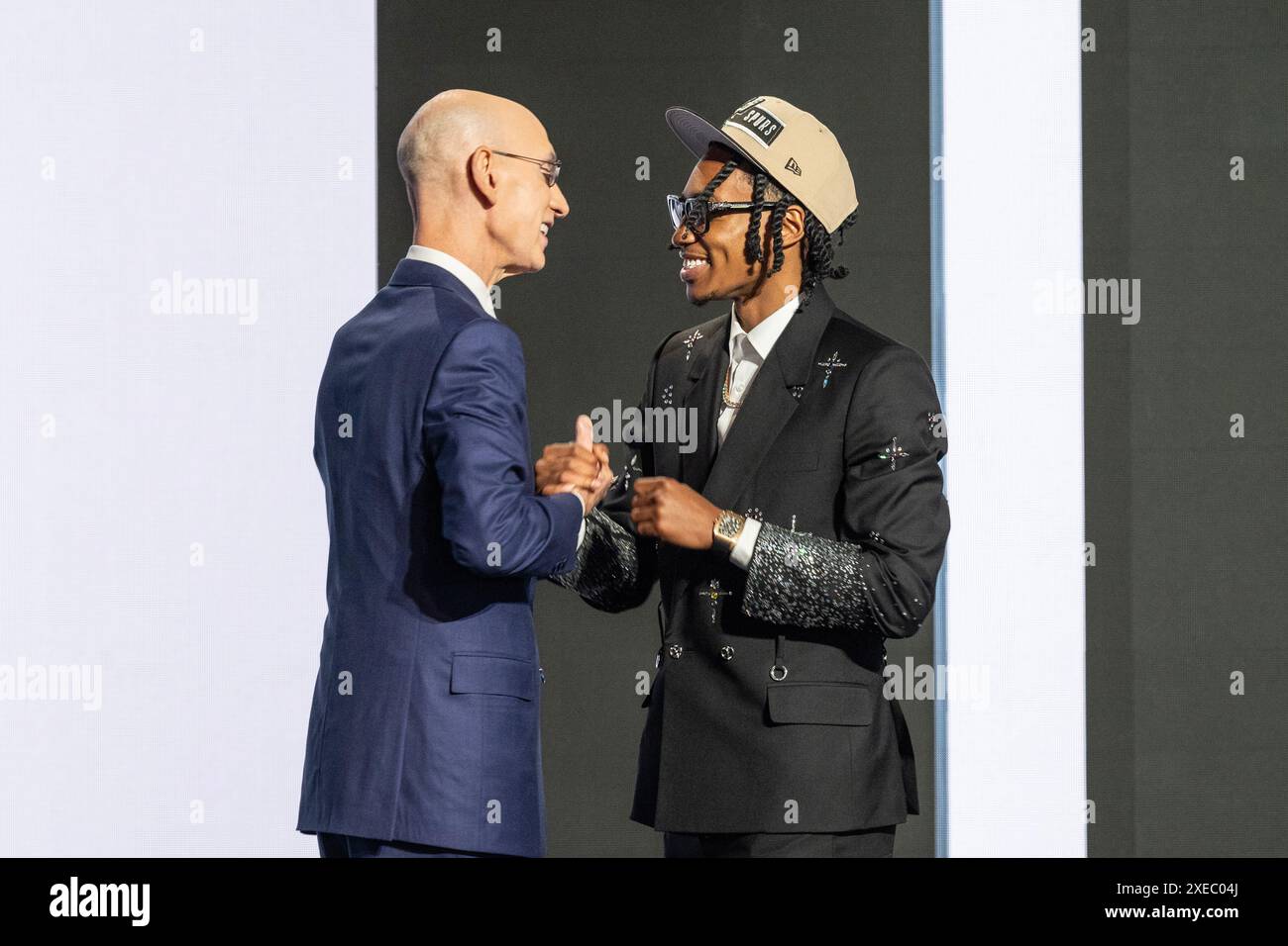 Commissioner Adam Silver shakes hands with Rob Dillingham, selected as ...