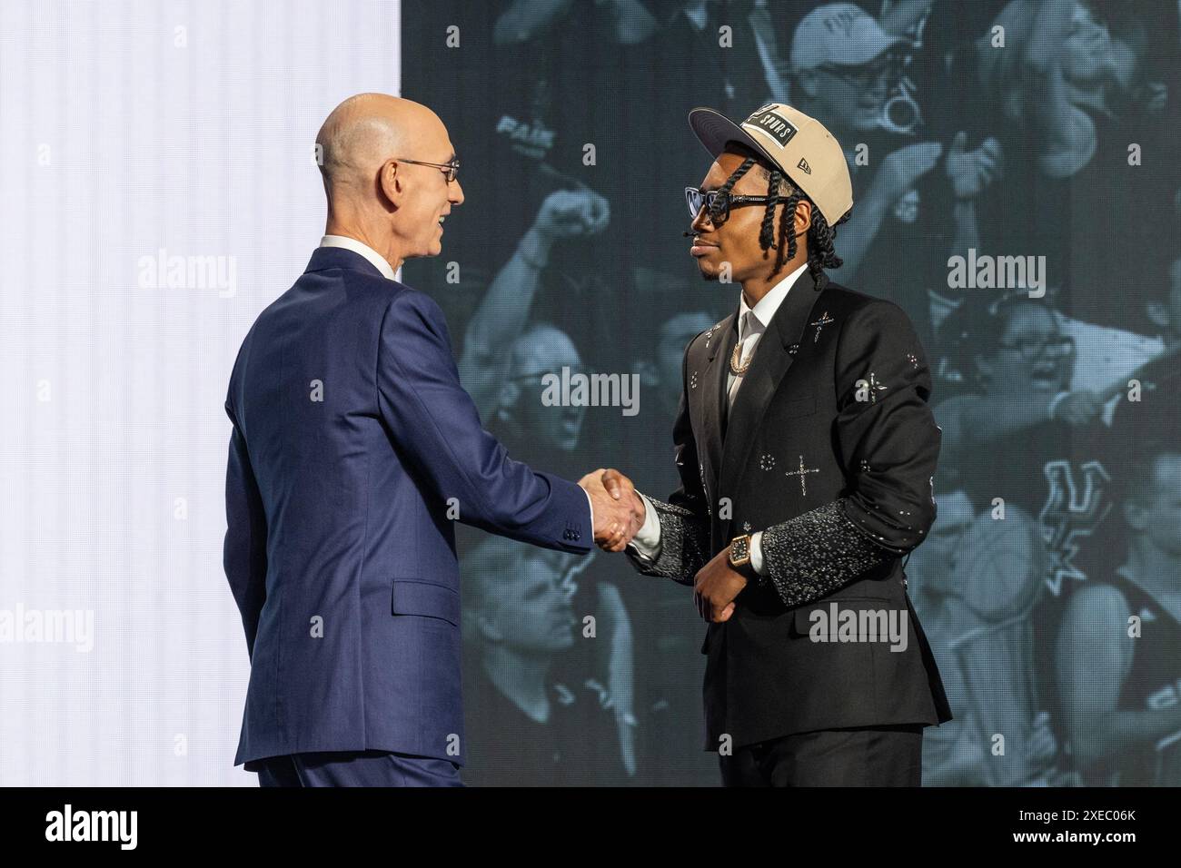 Commissioner Adam Silver shakes hands with Rob Dillingham, selected as ...