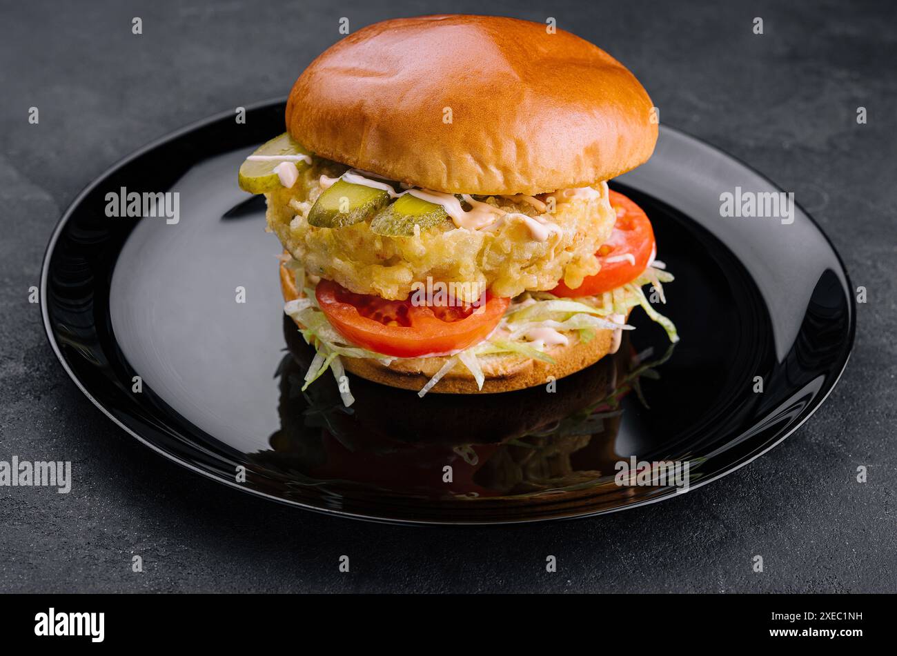 Fried fish fillet burger on black plate Stock Photo - Alamy