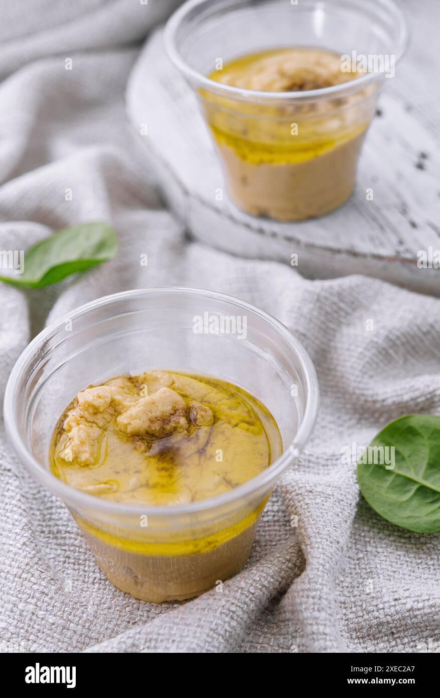 homemade hummus in a plastic cups with basil Stock Photo - Alamy