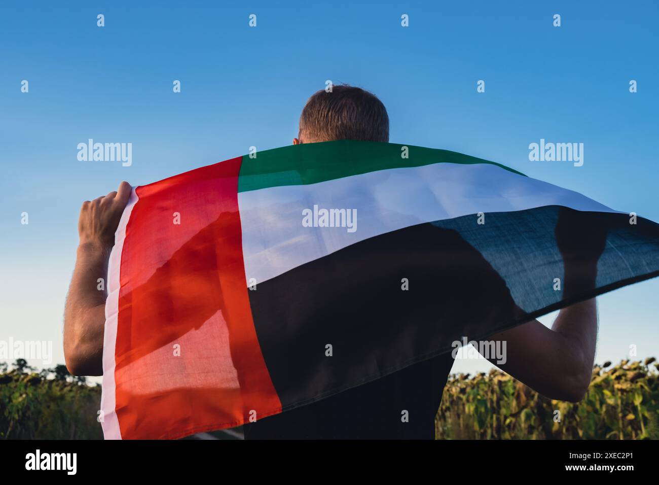 Man holding National Flag Of UAE Waving In The Wind sunset. Flag of ...