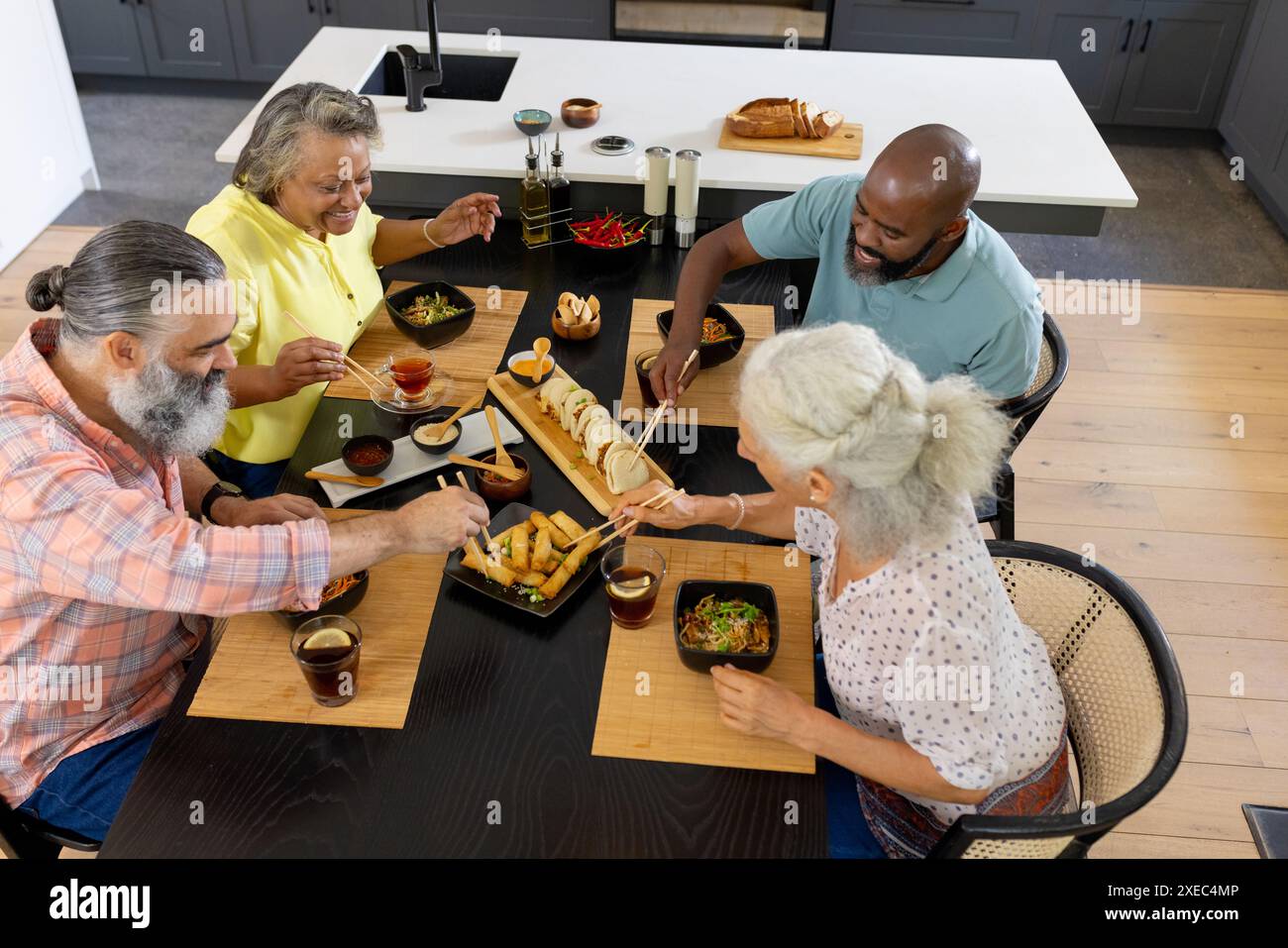 At home, Diverse group of senior friends enjoying meal together ...