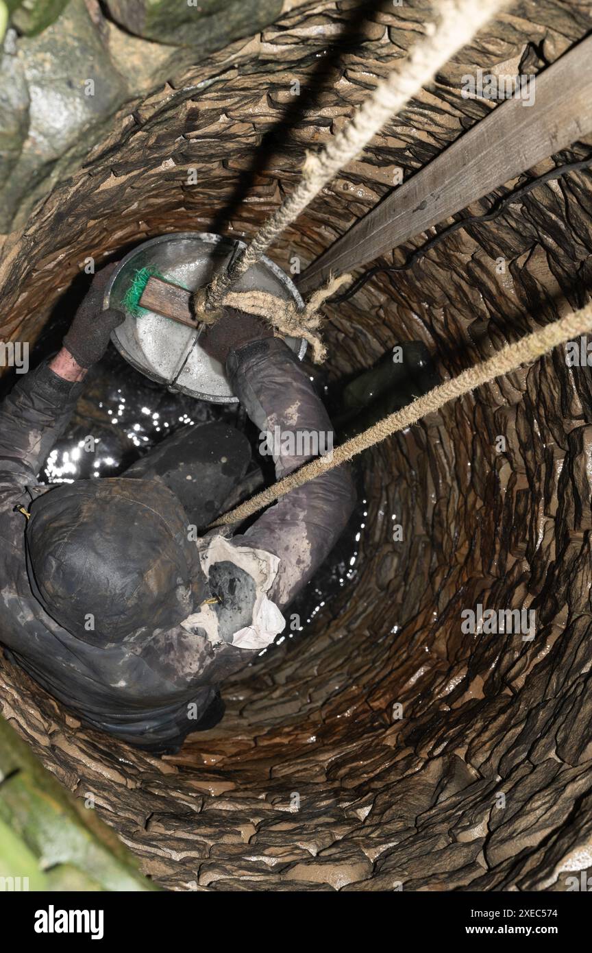 A man disinfects stones inside a well after cleaning the bottom Stock ...