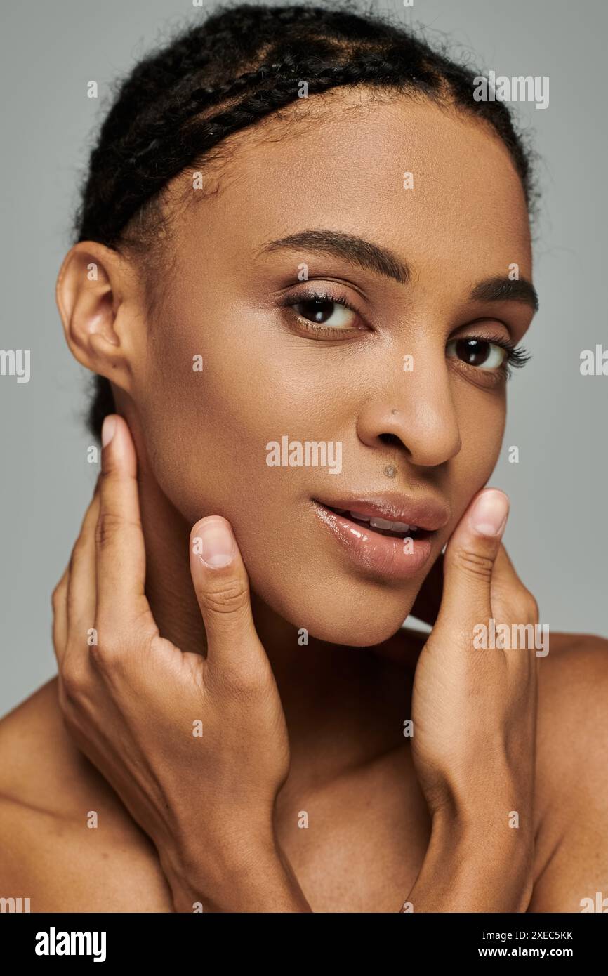 Beautiful African American woman delicately touching her face with care ...