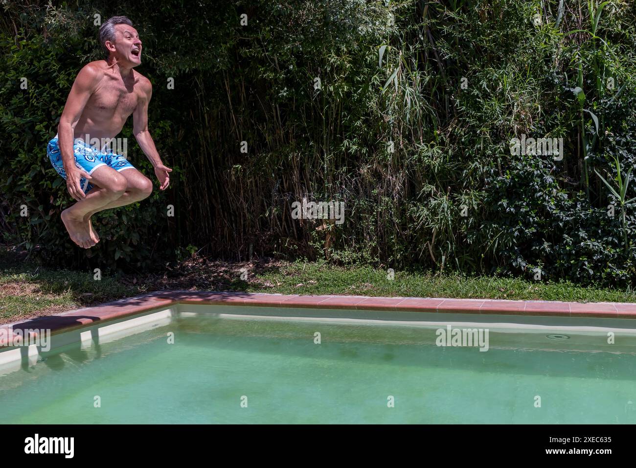 A man dives into the pool with an amused look Stock Photo - Alamy