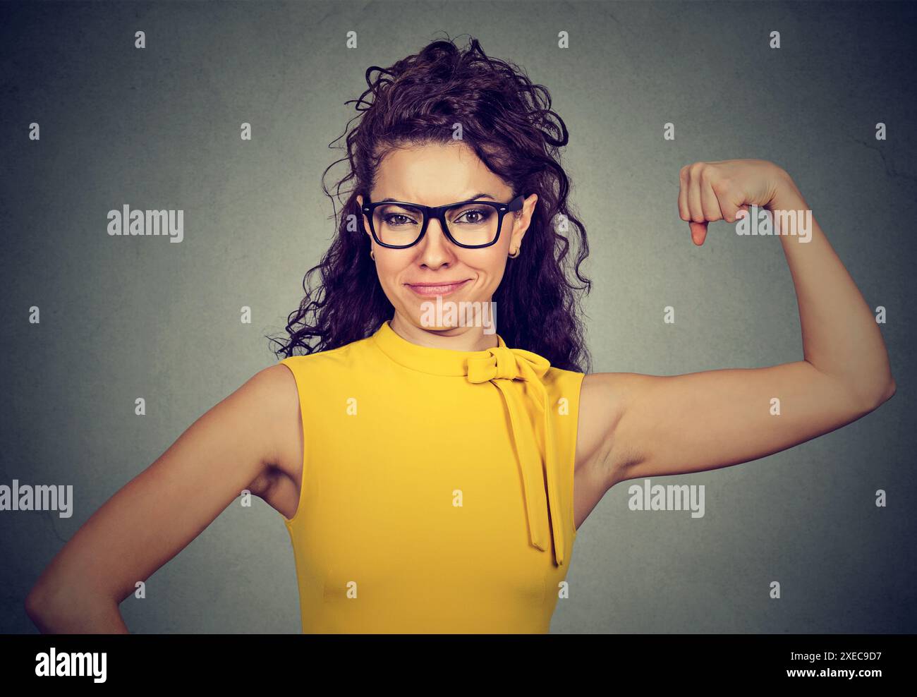 Happy successful strong young woman flexing her biceps Stock Photo - Alamy